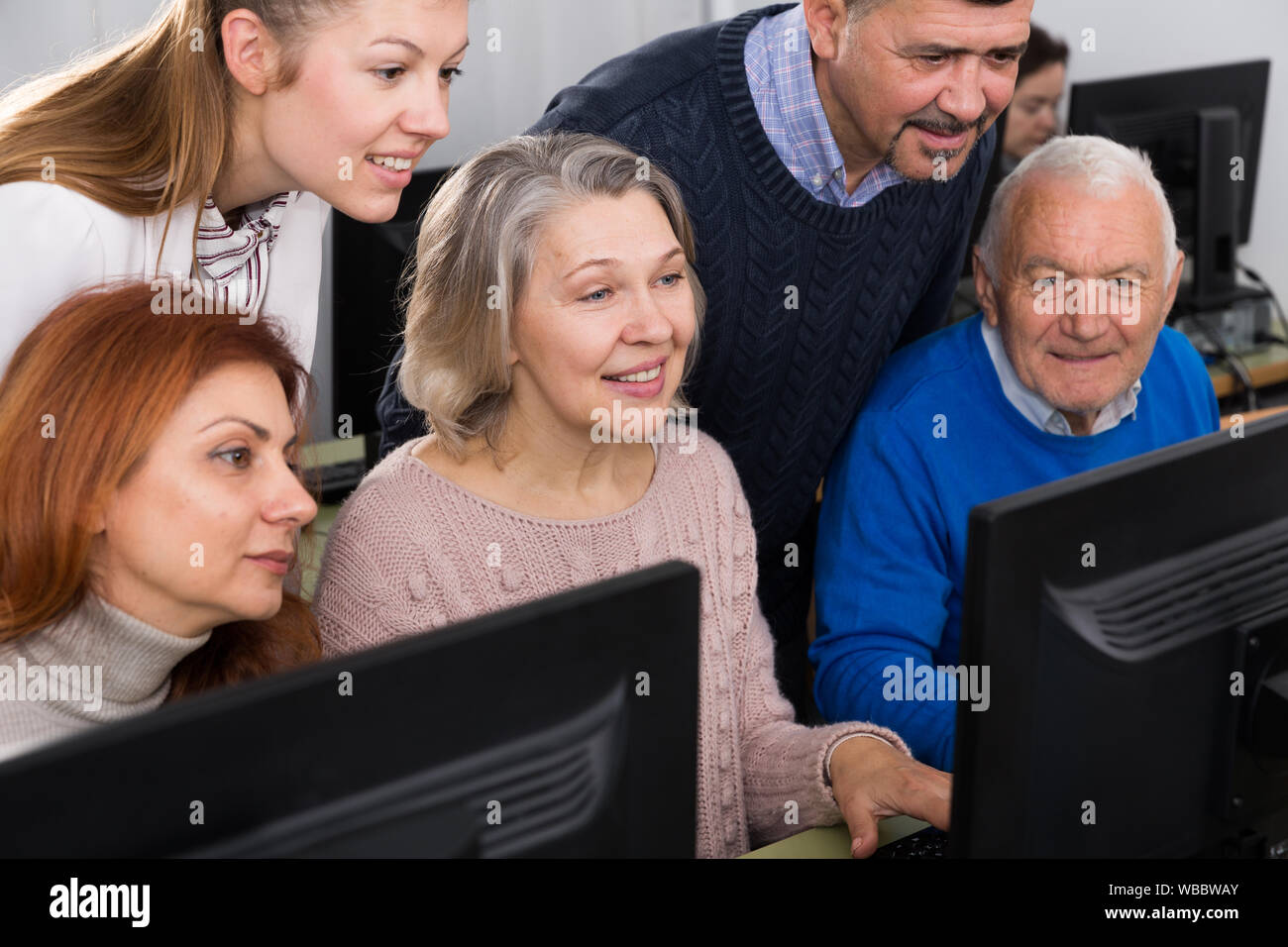 Business people grouped around laptop hi-res stock photography and ...
