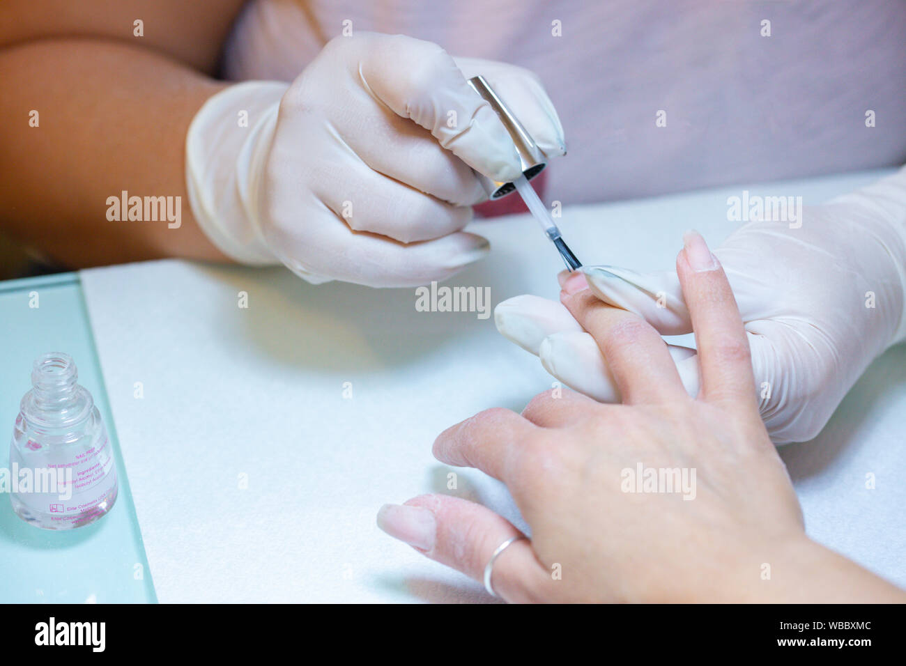 Nail beautician at work while performing the decoration and maintenance ...
