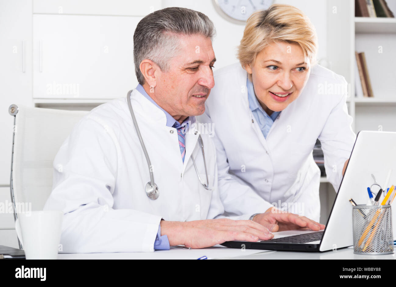 Doctor and nurse reading patient information in hospital computer ...