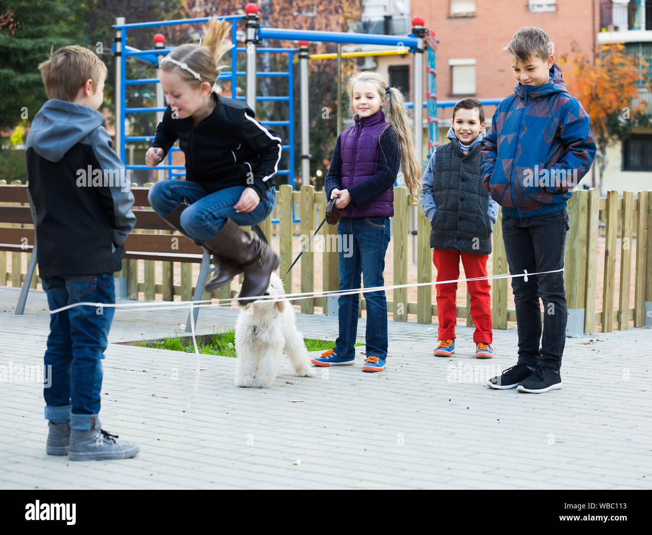 happy spanish kids skipping on chinese jumping elastic rope in yard ...