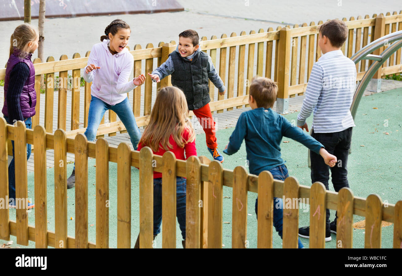 Group of happy cheerful children playing romp game Touch-last outdoors ...