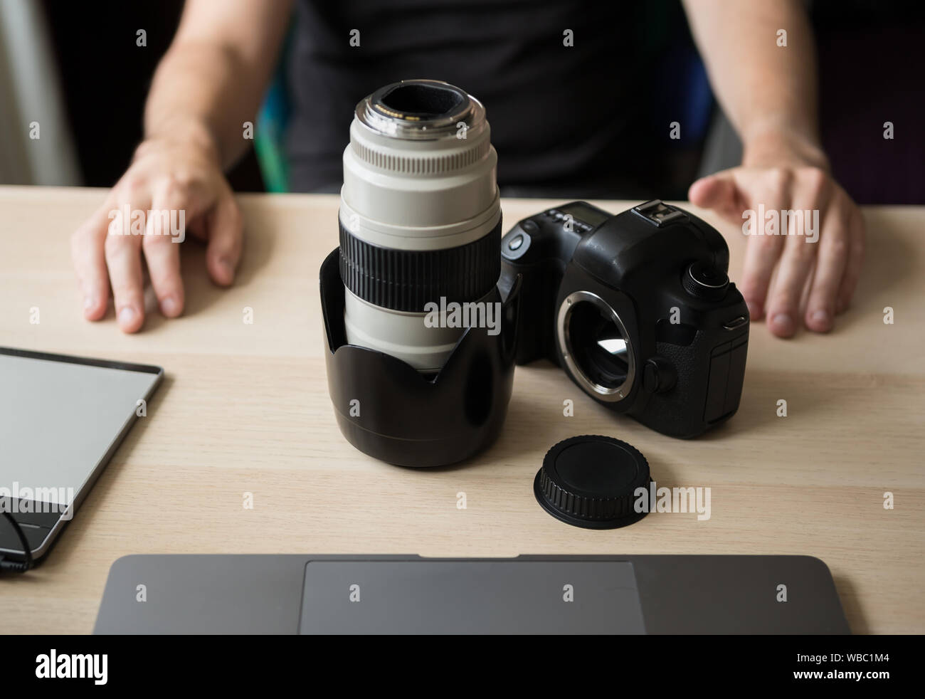 Professional male photographer sitting at desk in photostudio.Big white ...