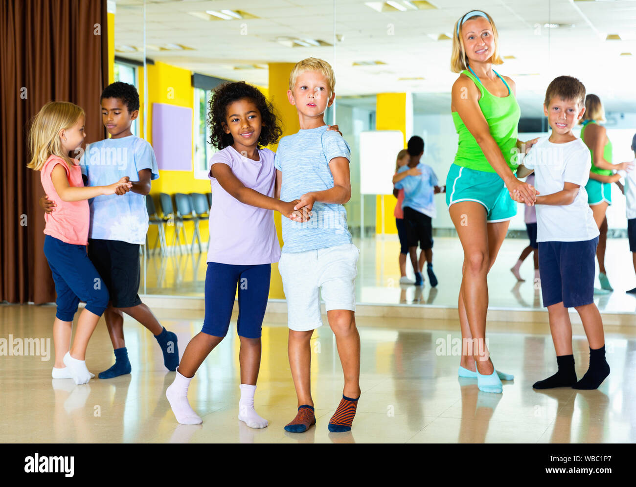 Diligent friendly smiling children dancing together slow ballroom ...