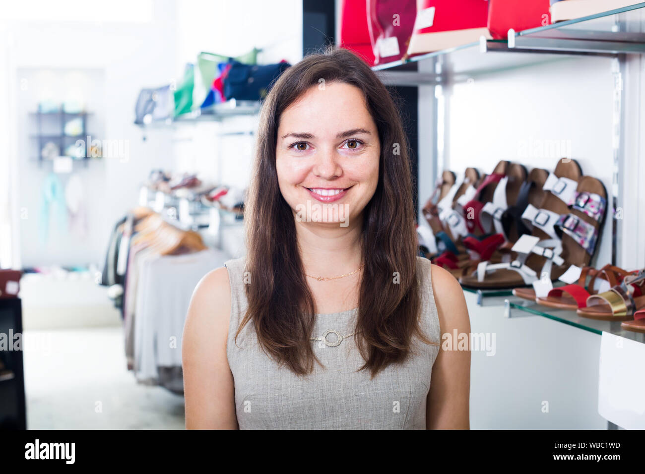 Footwear shop smiling girl posing with different shoes Stock Photo - Alamy