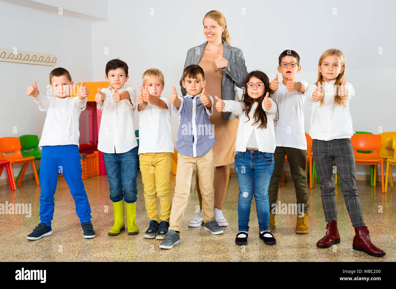 Portrait of happy cheerful positive smiling female teacher with her ...