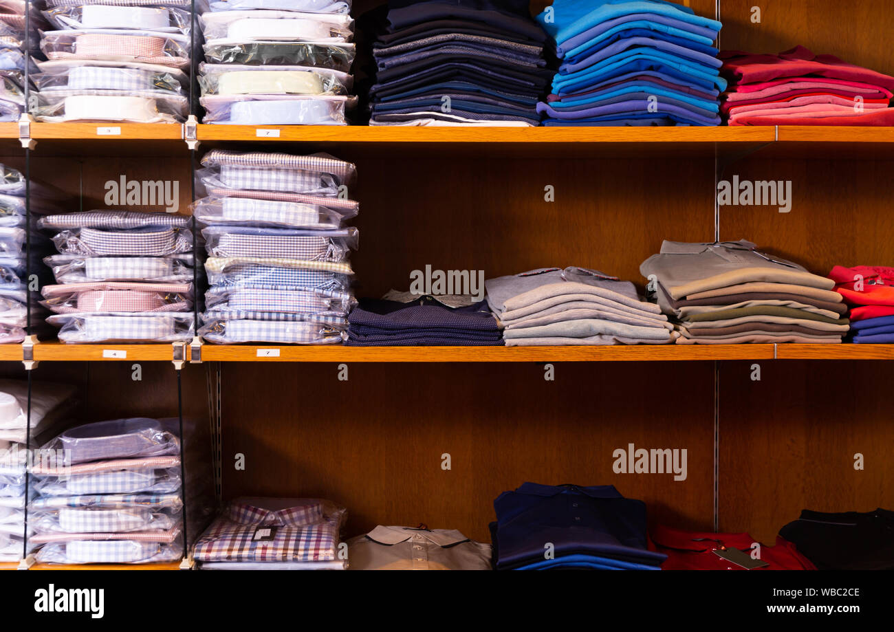 Clothing store. Shelves with shirts of different sizes Stock Photo - Alamy