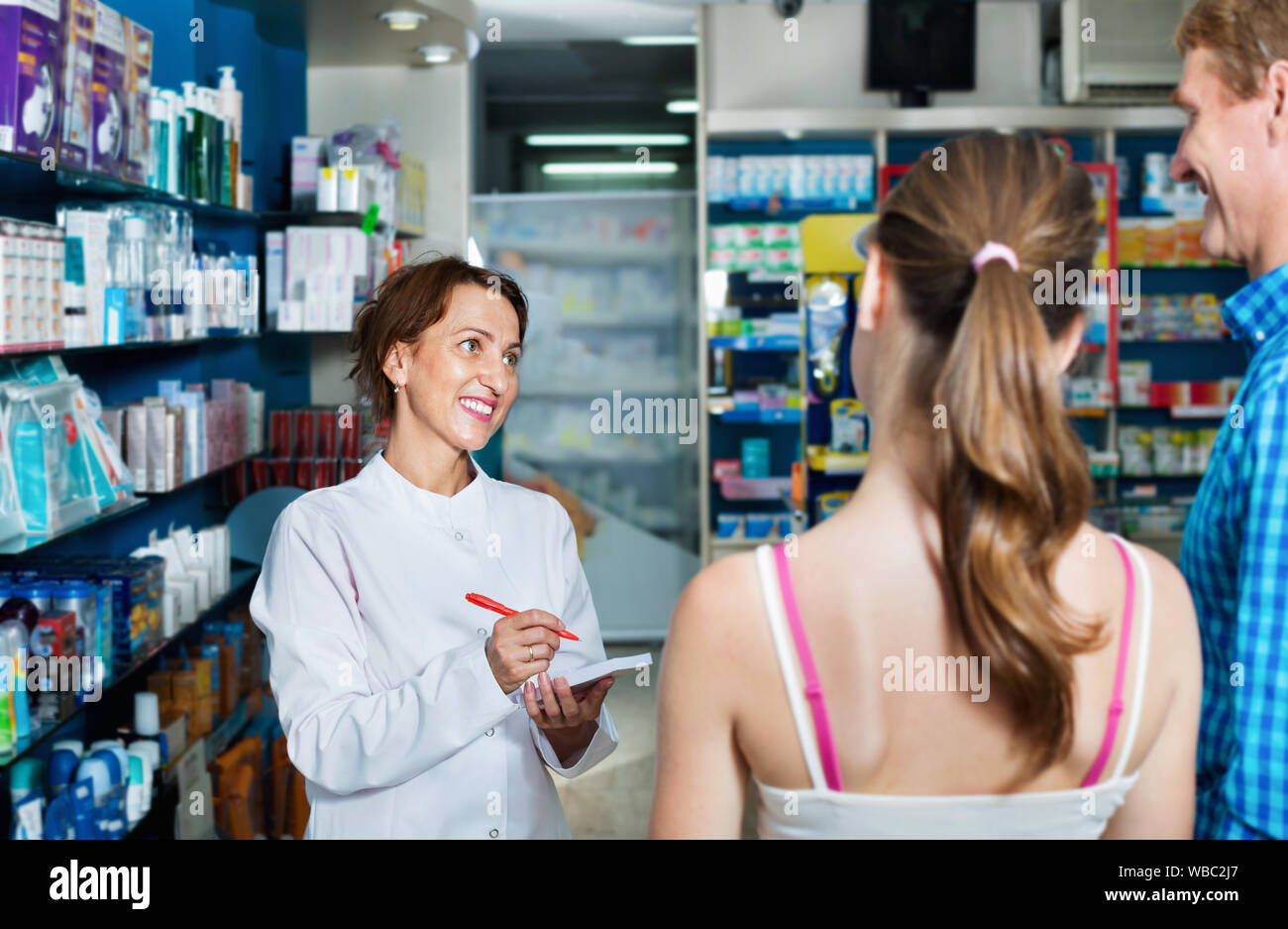 Diligent friendly female pharmacist wearing uniform working in ...