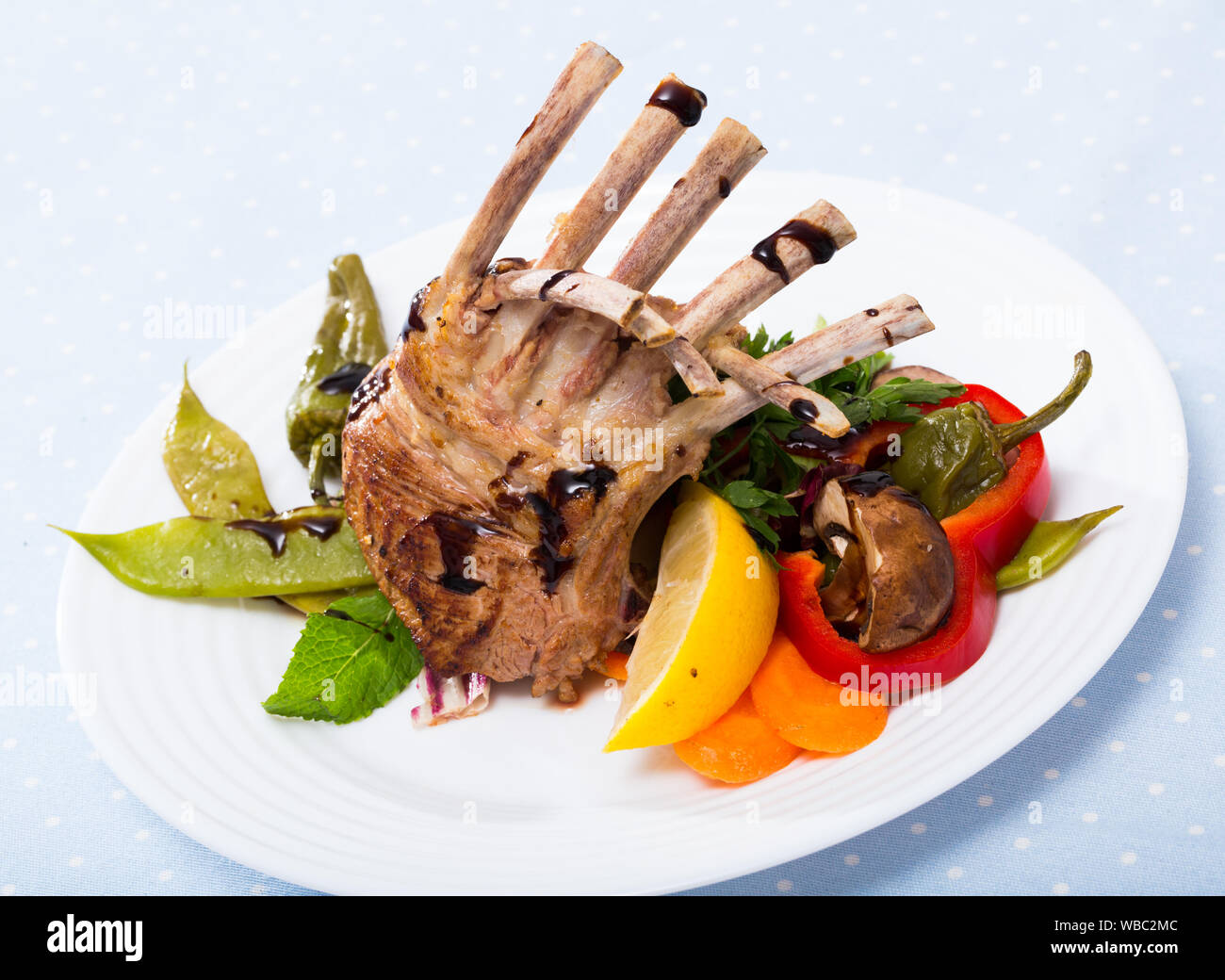 Rack of mutton chops surrounded by assorted fresh vegetables and mint ...