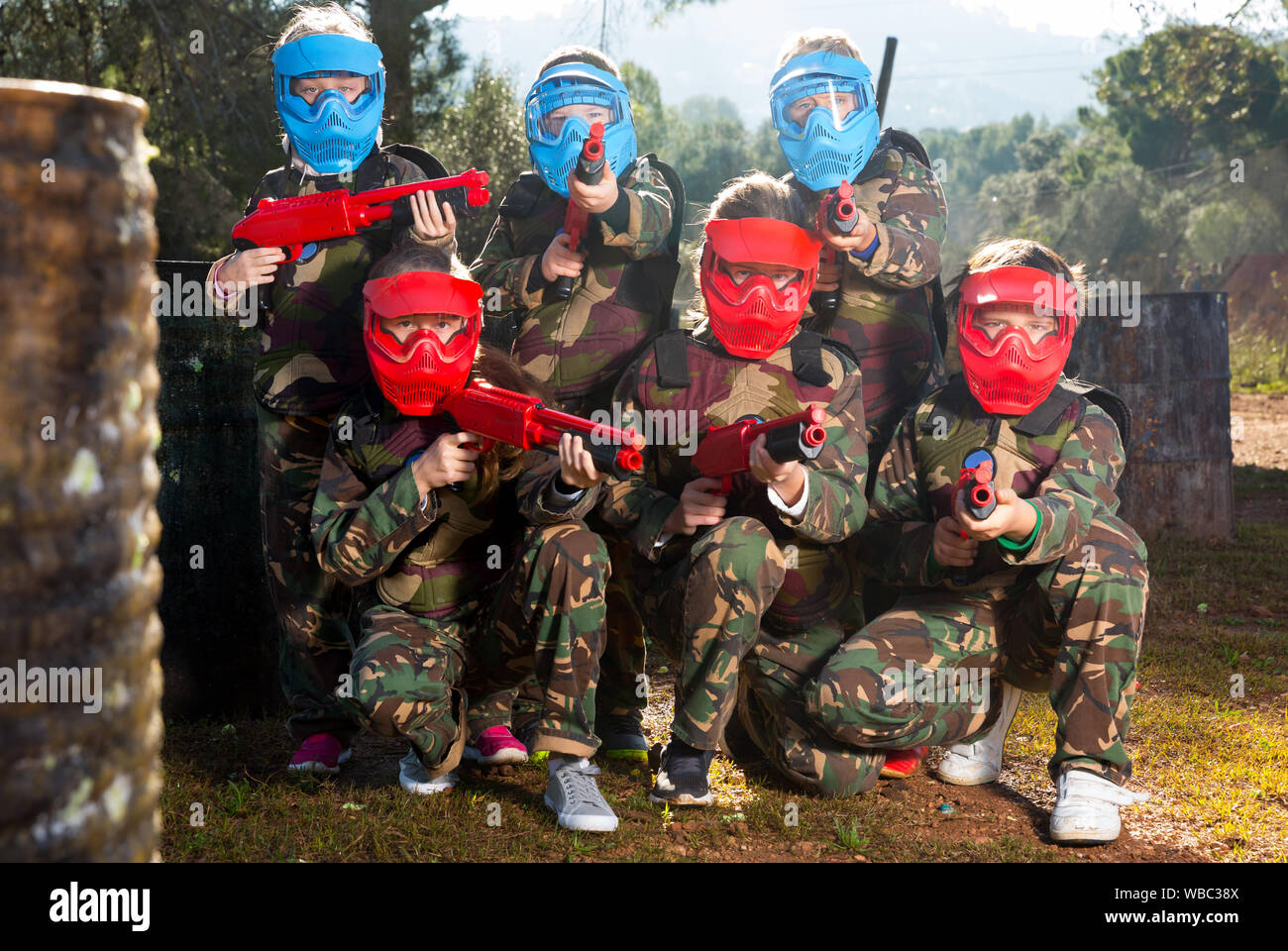 Portrait of group of boys and girls paintball players with marker guns ...