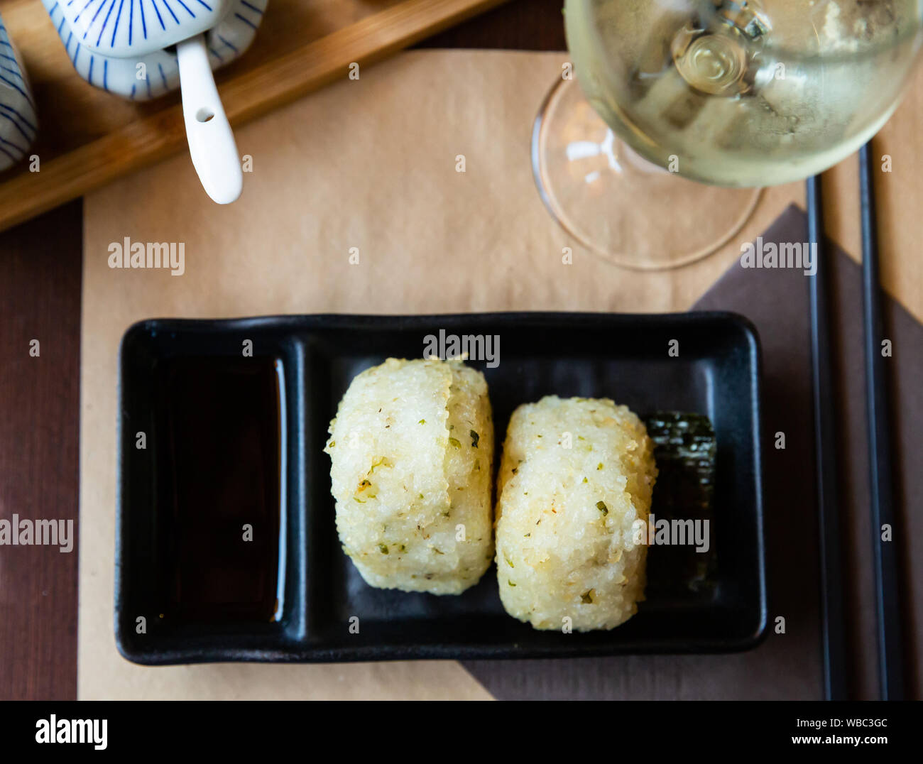 Fresh Japanese triangular onigiri with rice at black plate, nobody ...