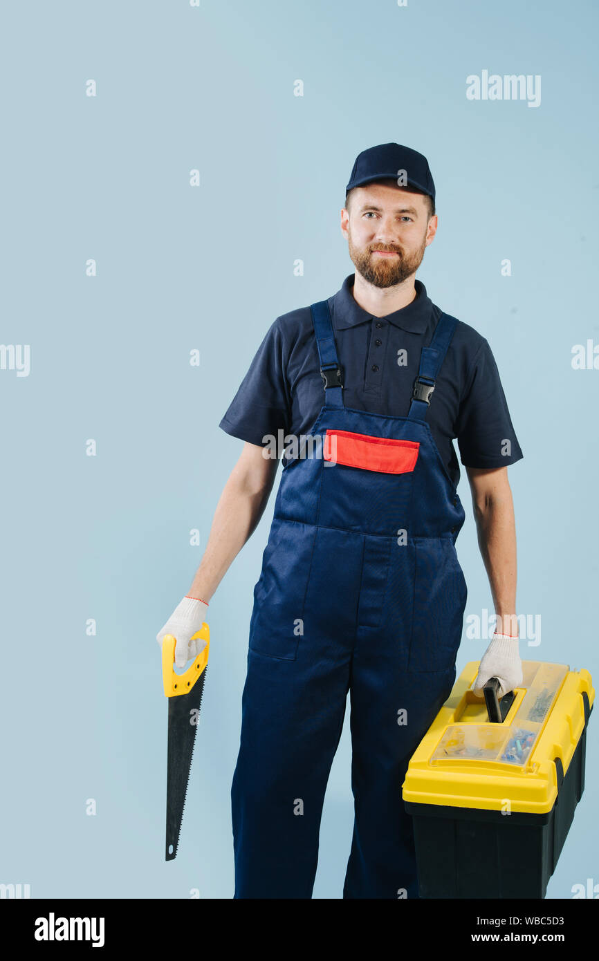 Portrait of confident service worker with saw and tool case, dressed in ...