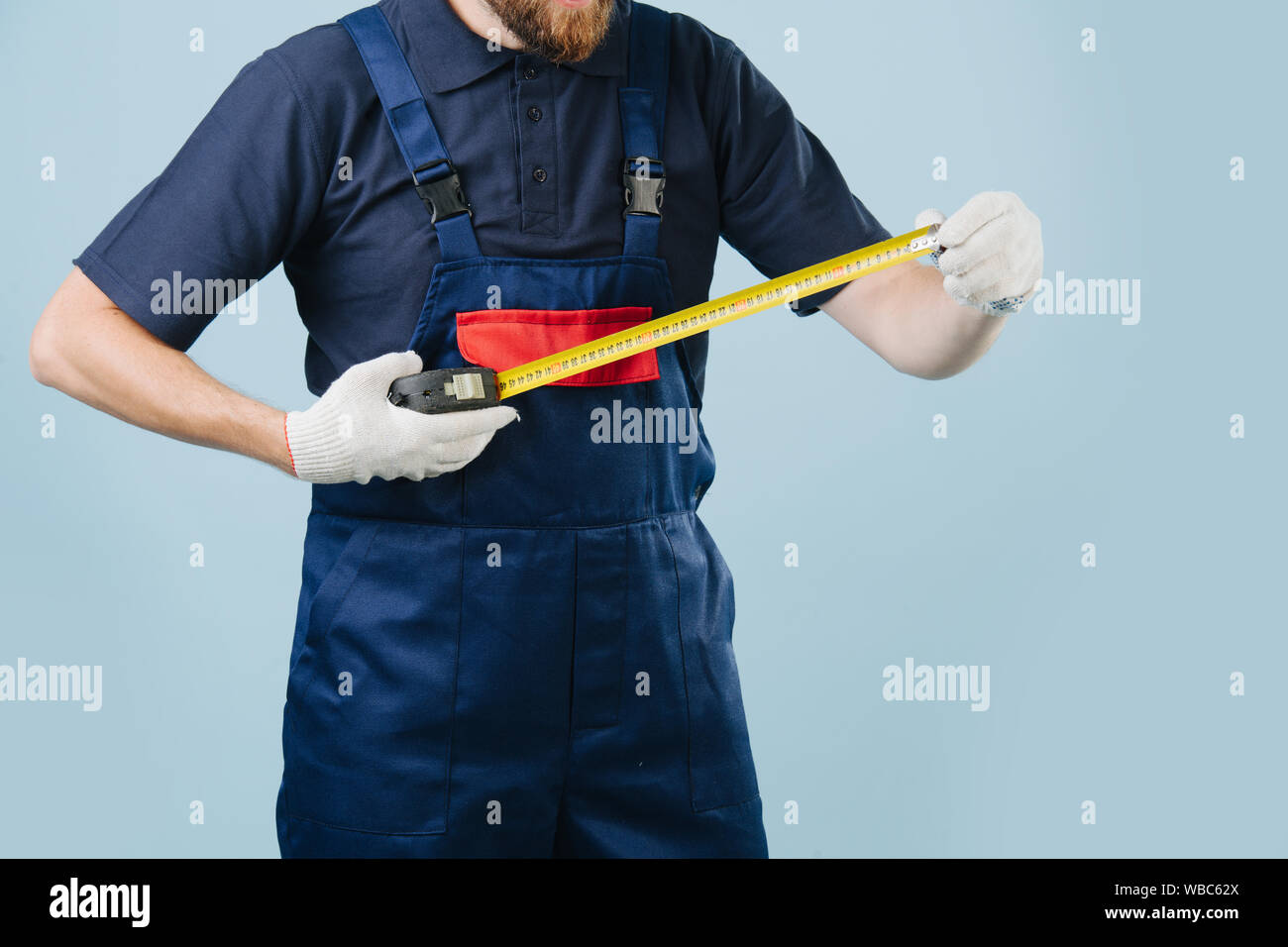 Service worker with tape-meter in hands, dressed in uniform Stock Photo ...
