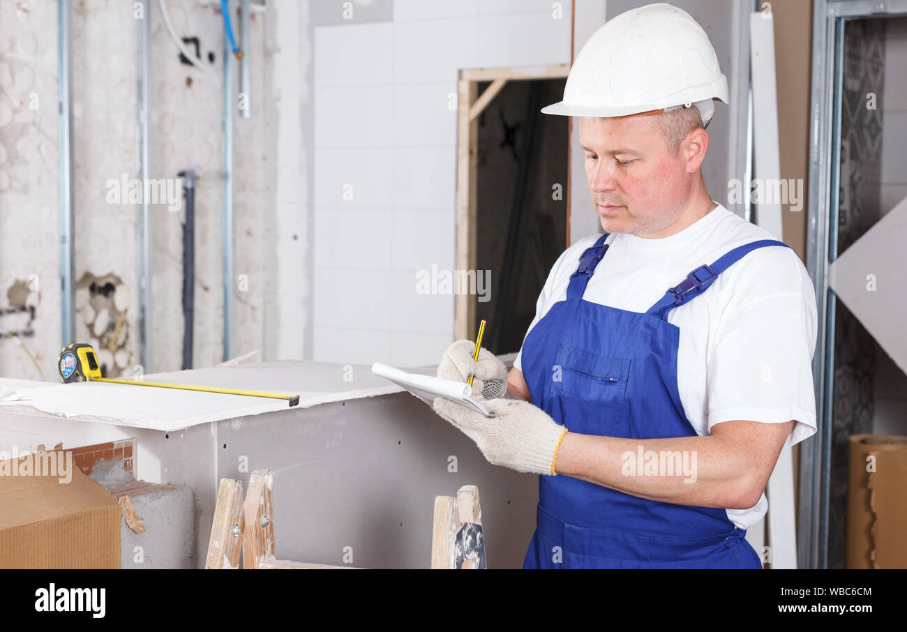 Professional male contractor looking at room and determining scope of ...