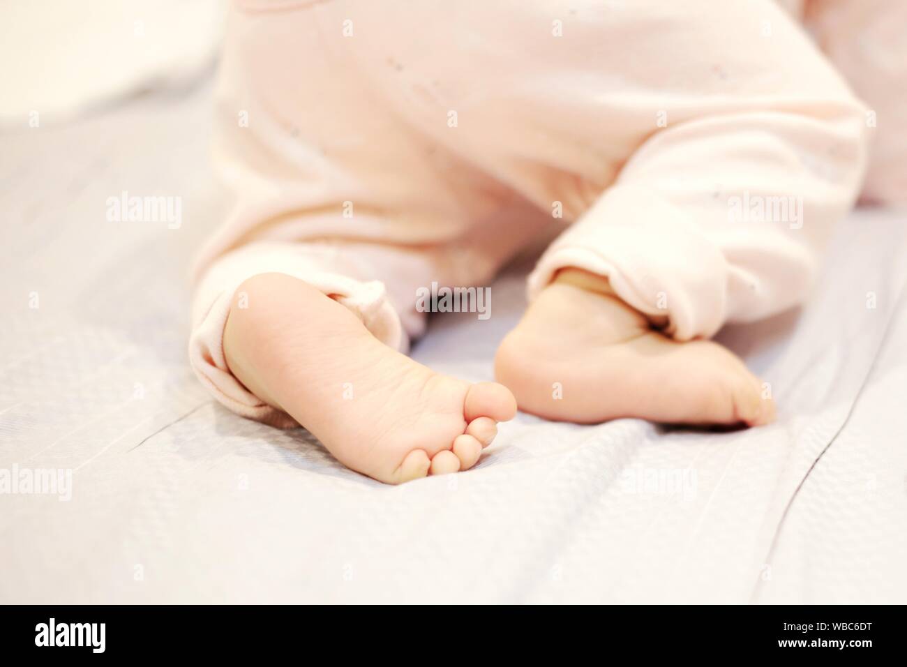 baby crawling on the bed. cute little baby feet pushing. soft and ...