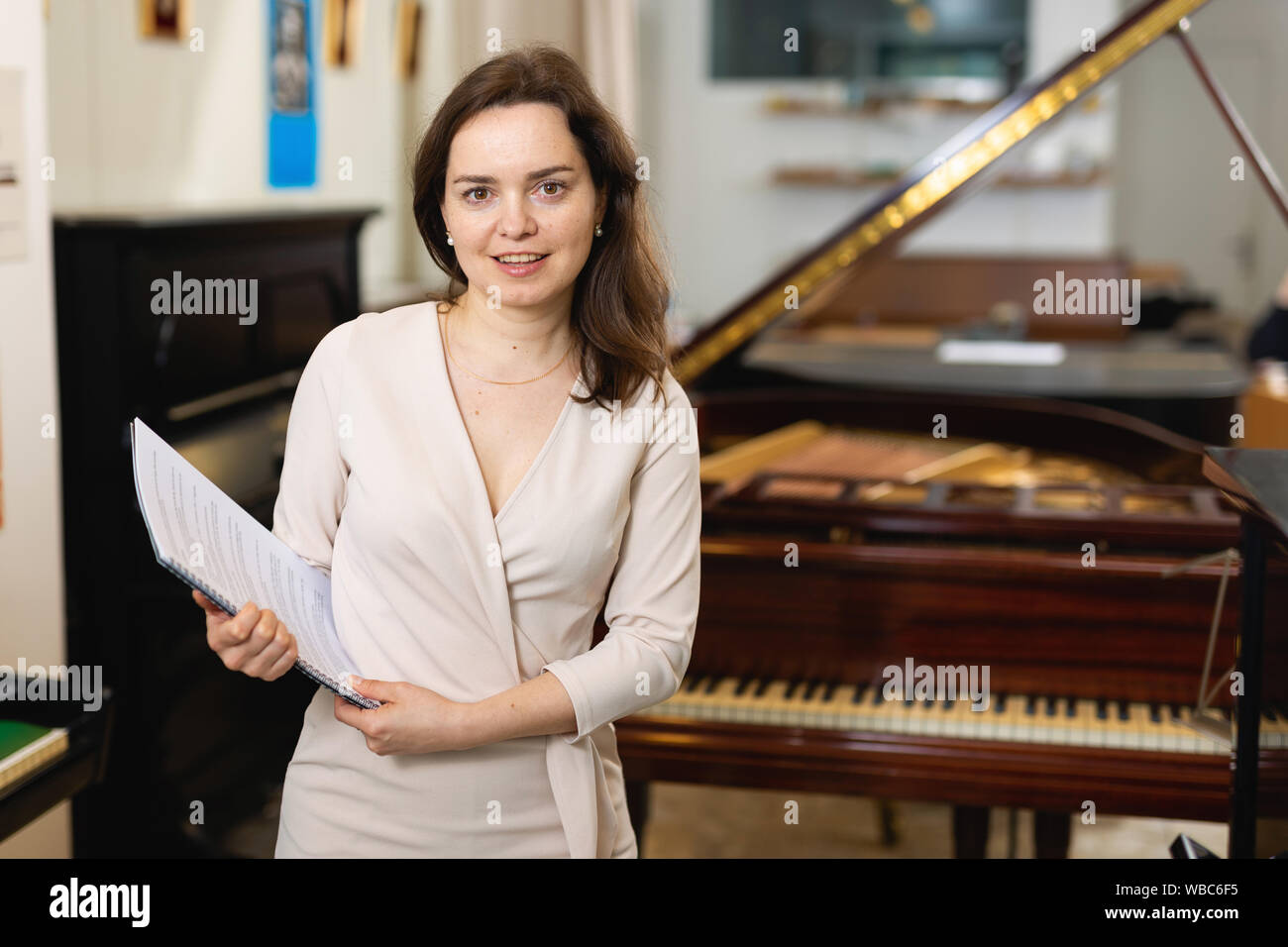 Pretty saleswoman in piano record store Stock Photo - Alamy