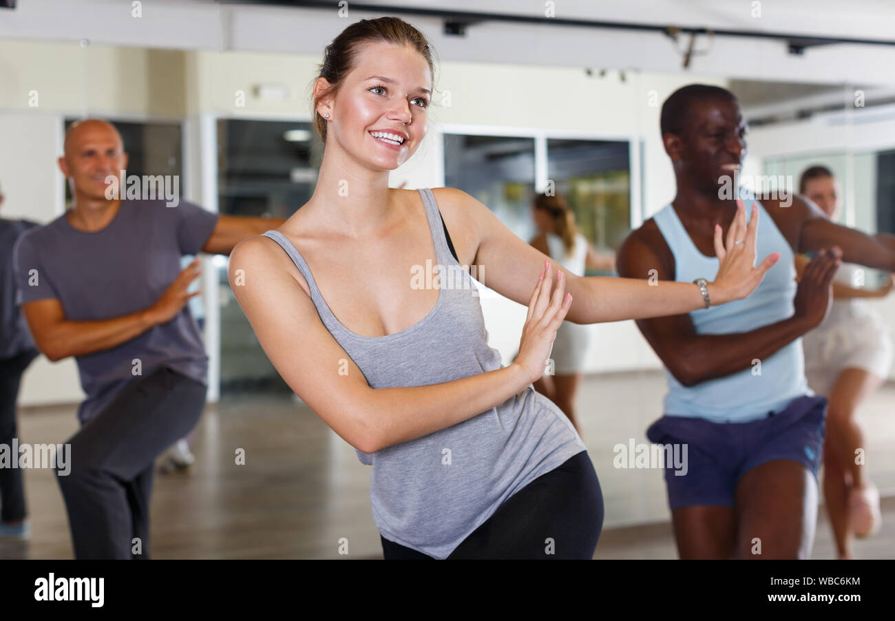Group of multinational smiling adult people enjoying active dance ...
