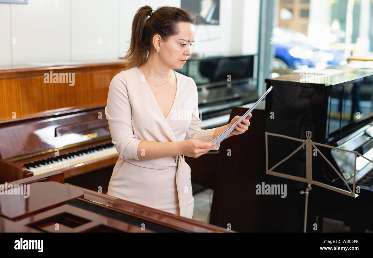 Pretty woman seller in piano music store Stock Photo - Alamy