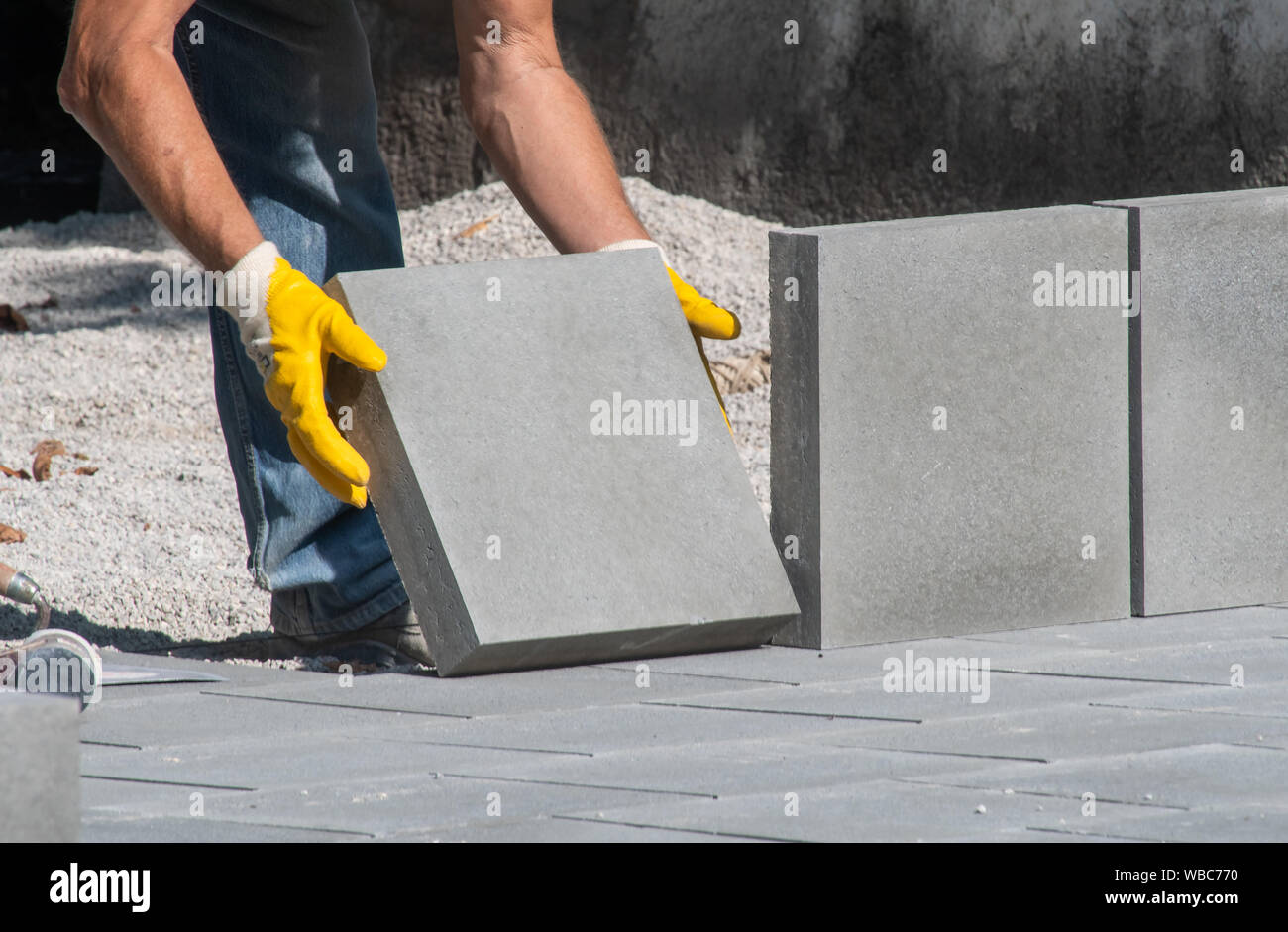Munich, Germany. 26th Aug, 2019. A construction worker lays pavement ...