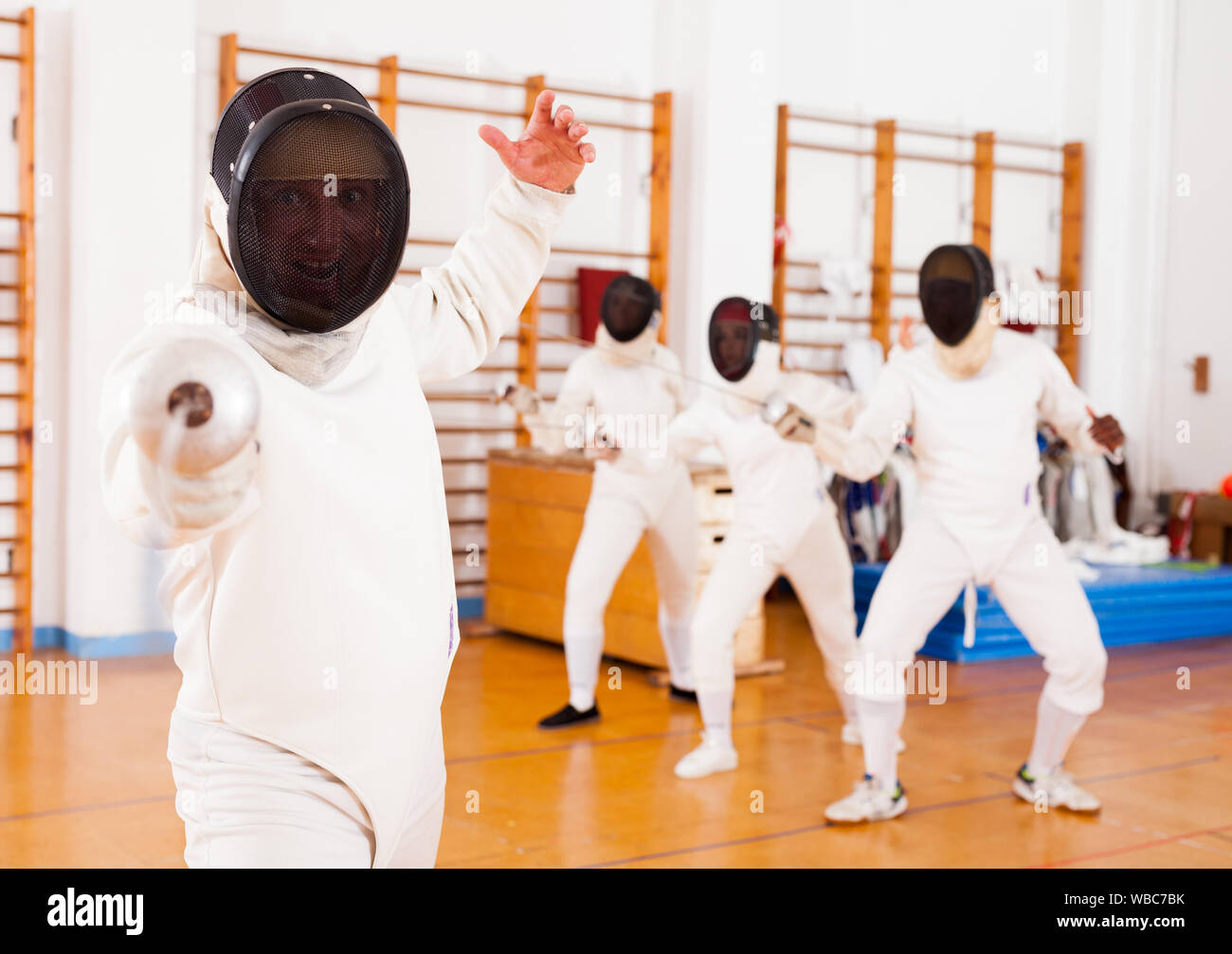 Sporty young man fencer practicing effective fencing techniques in ...