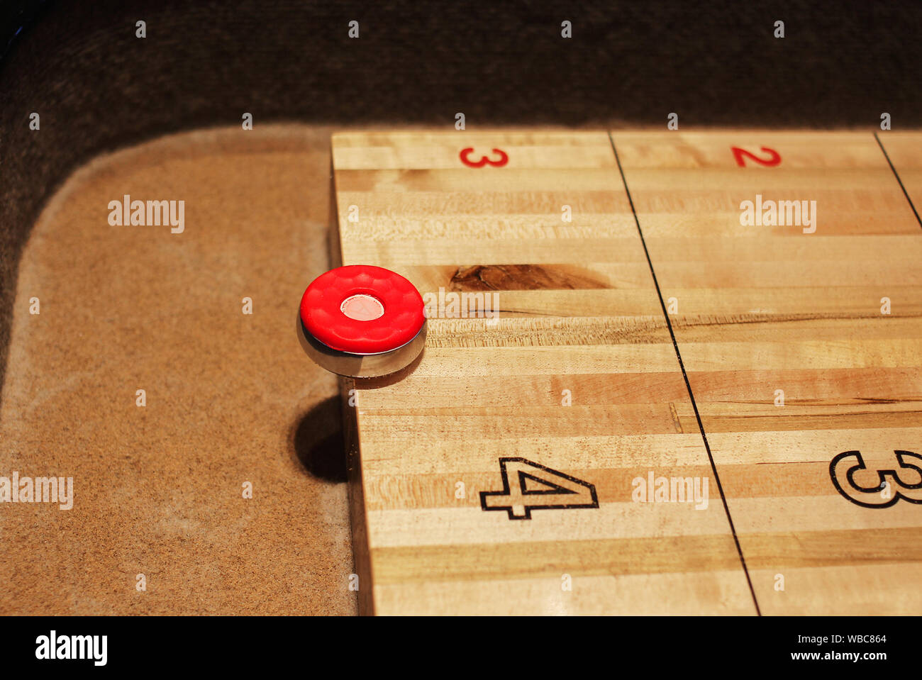 red shuffleboard disc on the table at five point mark. Shuffleboard ...