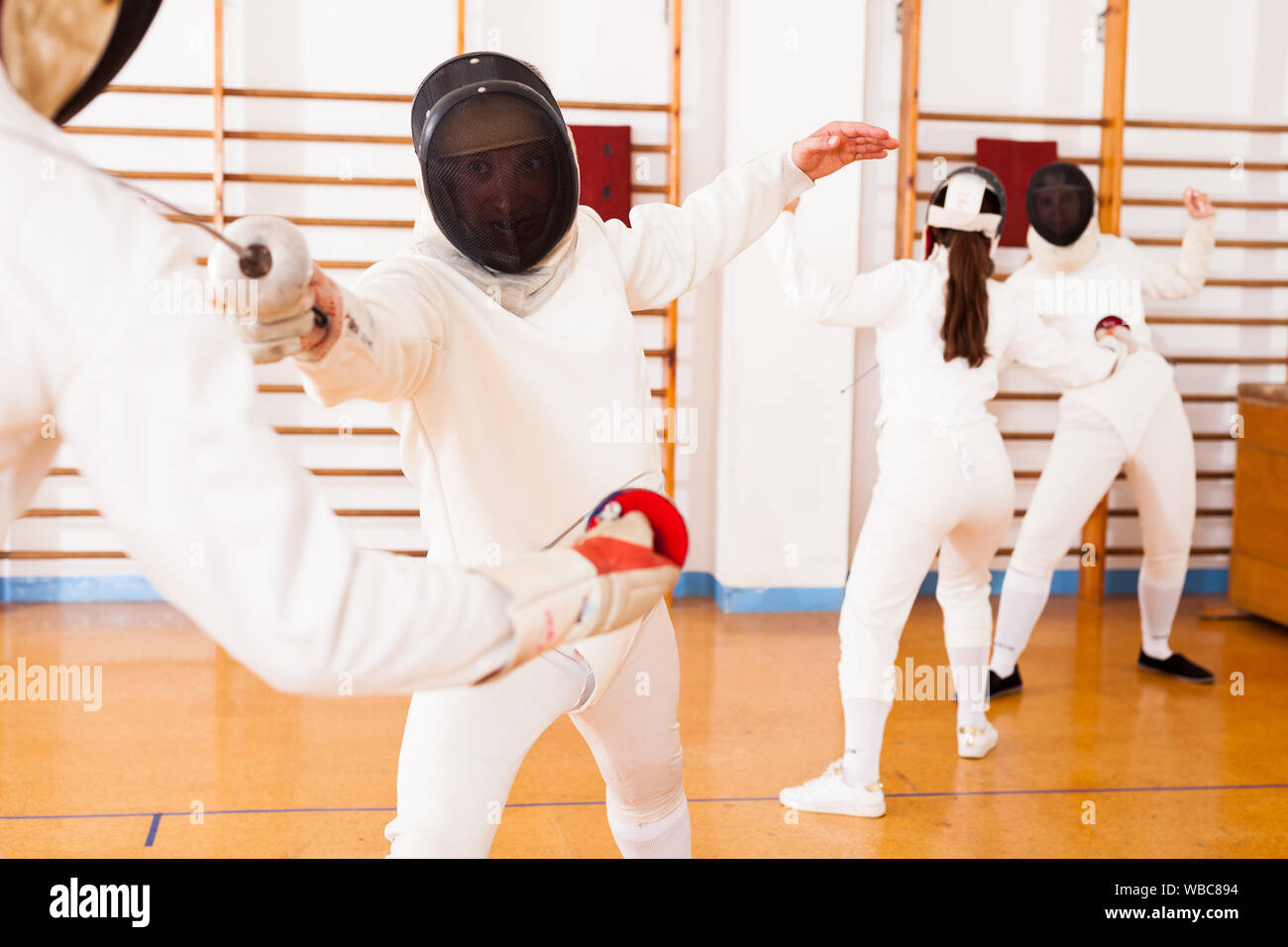 Portrait of athletes at fencing workout, practicing attack movements in ...