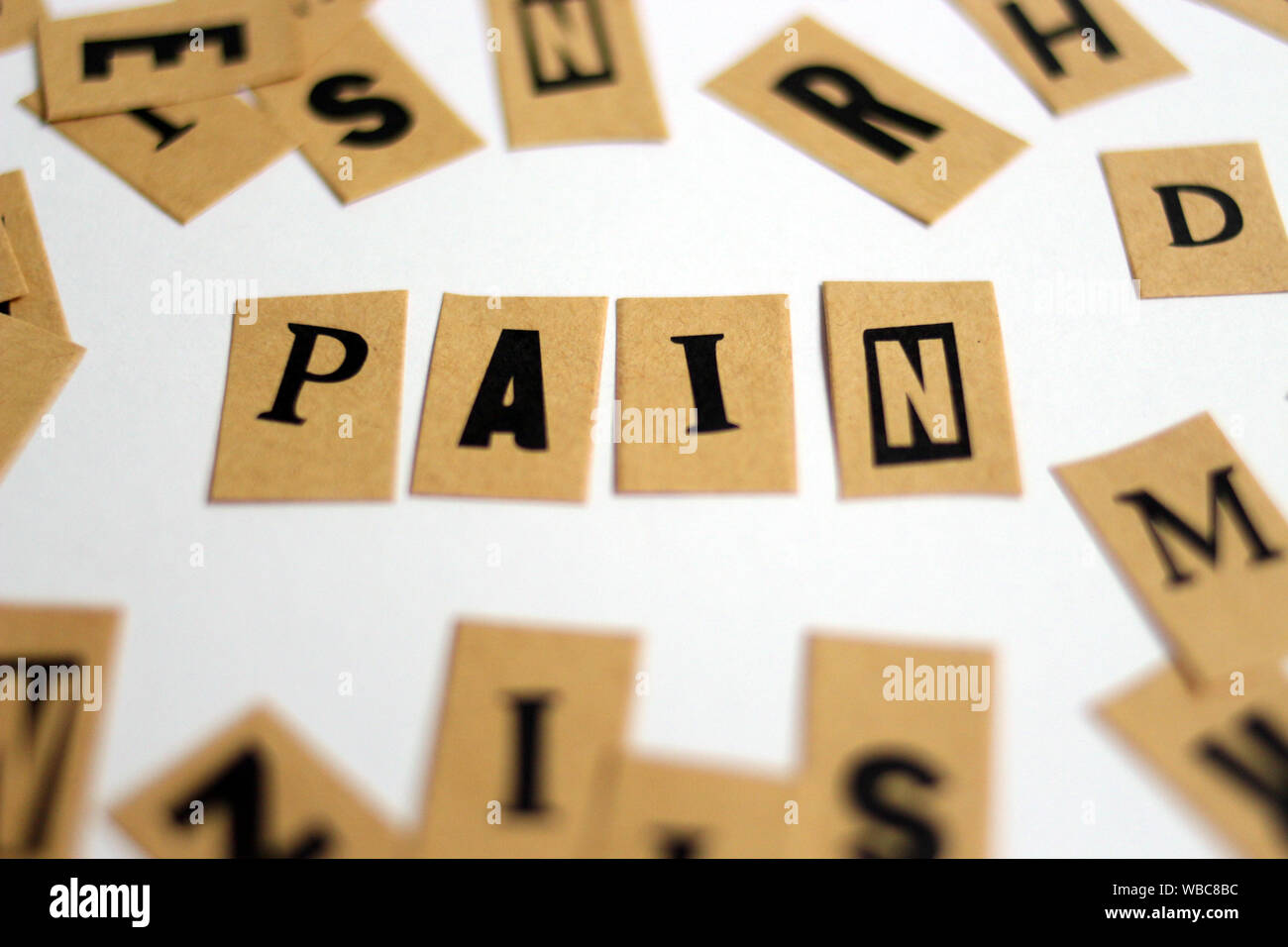 word PAIN spelled out on a table Stock Photo - Alamy