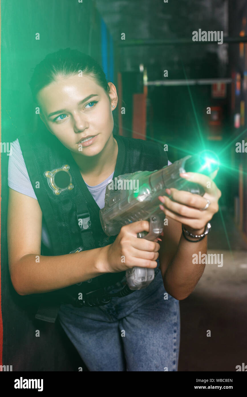 Young woman with laser guns took aim and posing during laser tag game ...