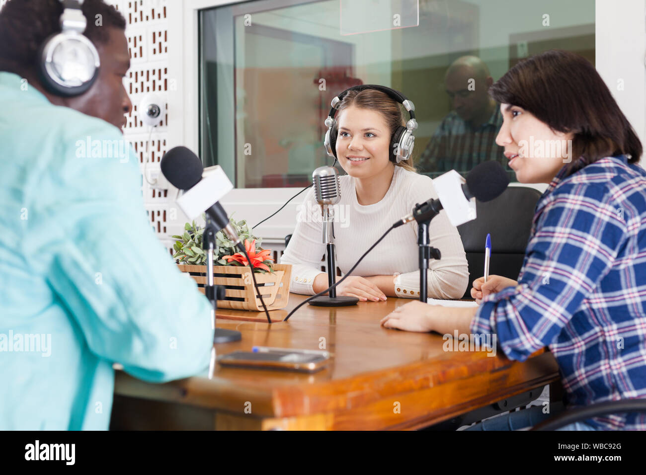 Cheerful presenters of different nationalities in sound broadcasting ...