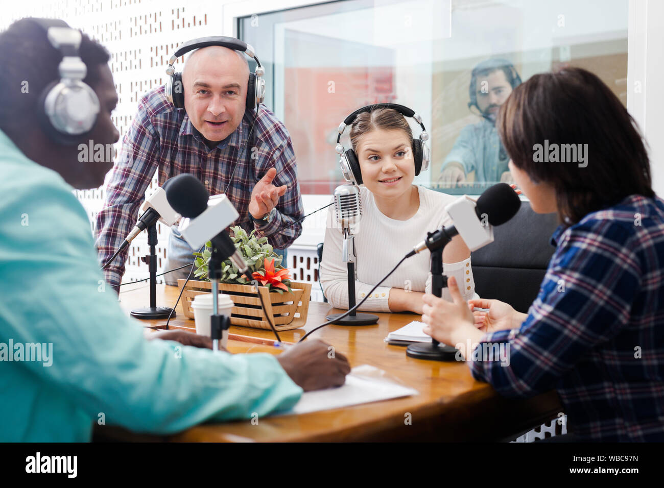 Smiling presenters of different nationalities in sound broadcasting ...