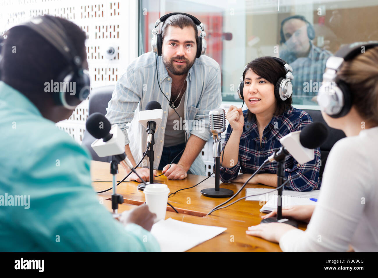 Joyful presenters of different nationalities in sound broadcasting ...