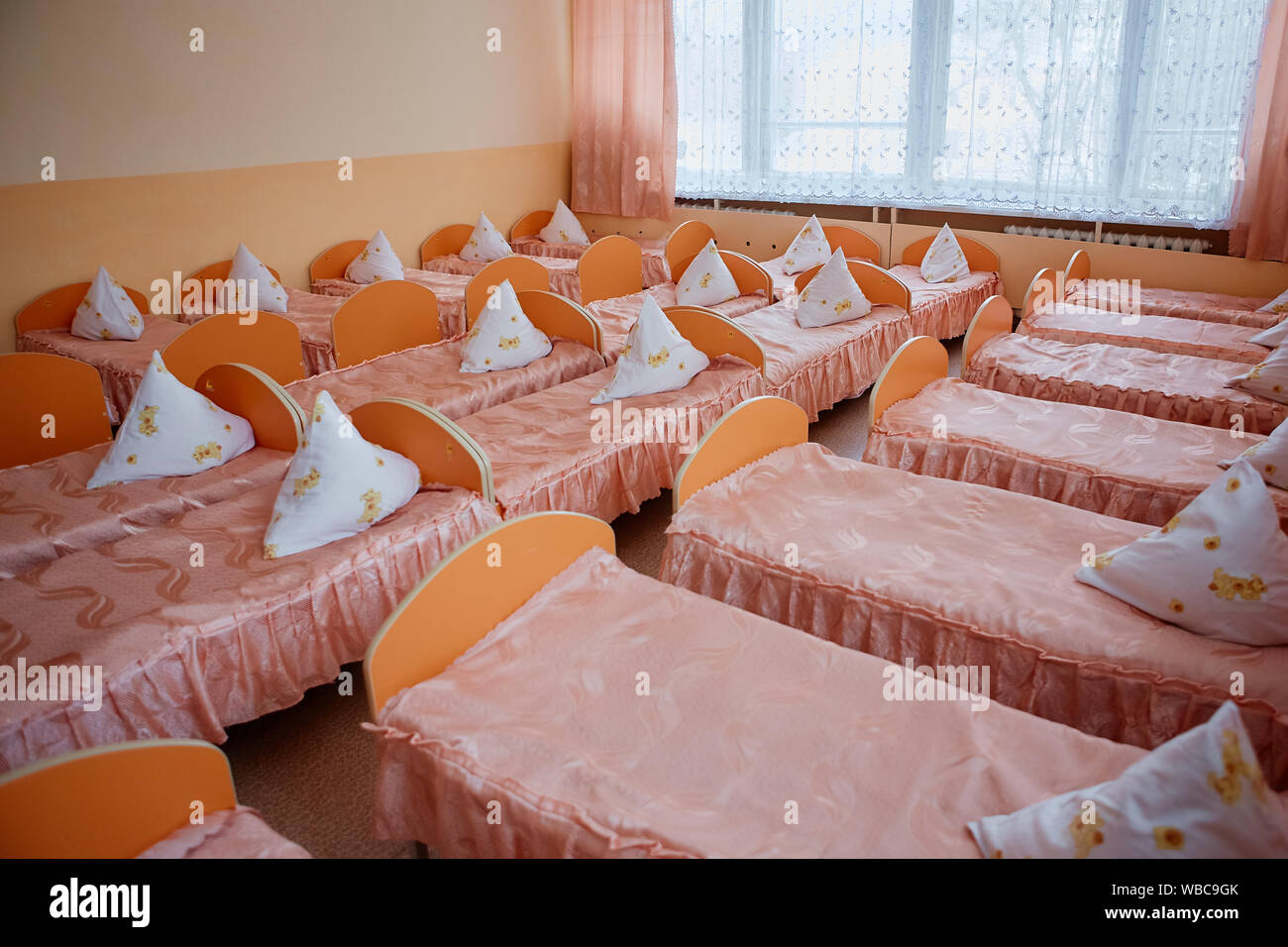 Beds and cots in brightly colored dormitory of a nursery.A lot of ...