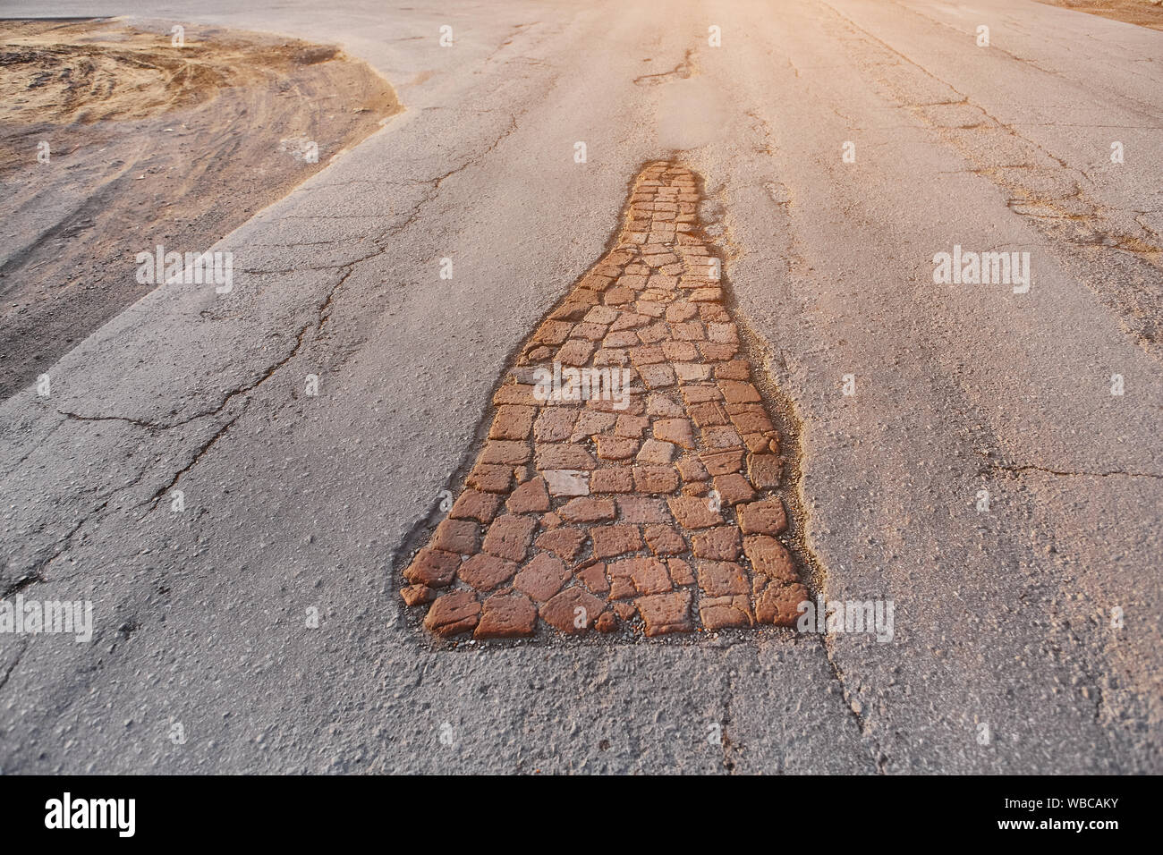 potholes in the road sealed with old bricks. Creative way to repair ...