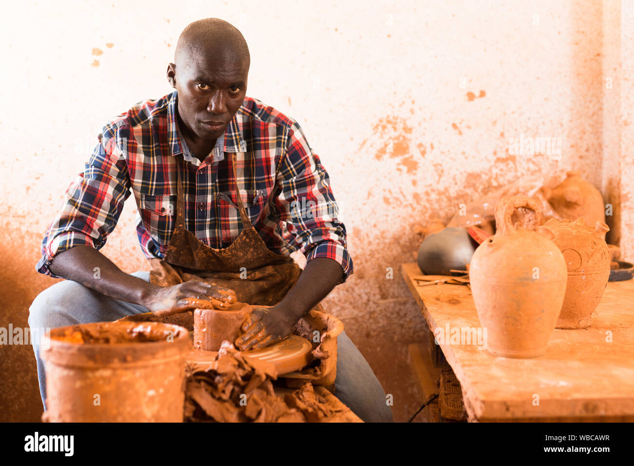 Talented young African potter at his own pottery studio working on new ...