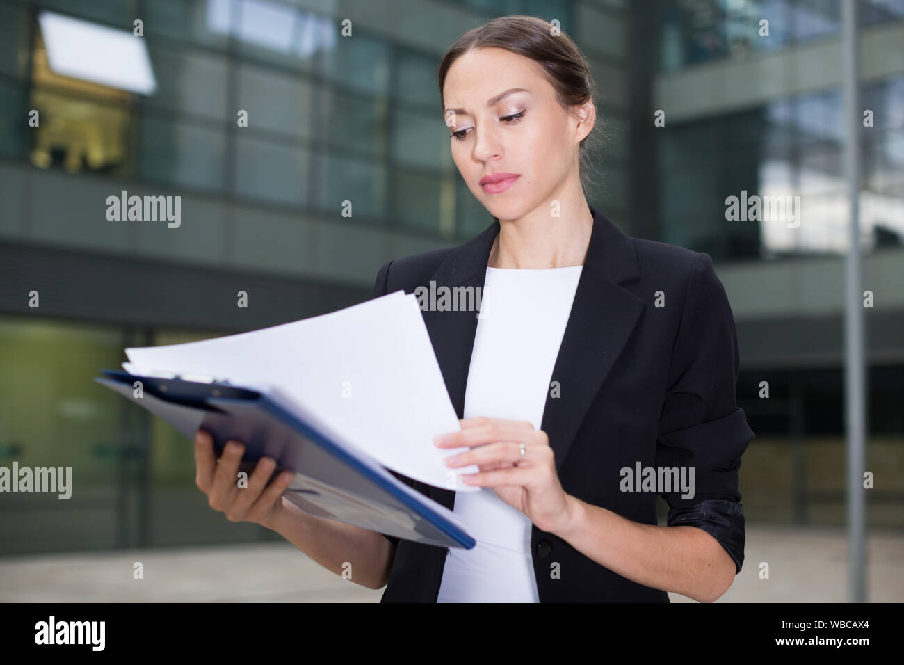 Female creative director is examining documents before signing outdoors ...