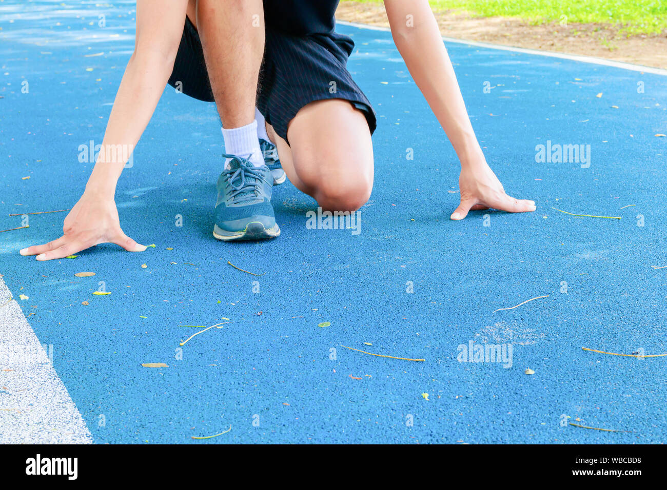 arm male touch floor start pose training running on track rubber blue ...