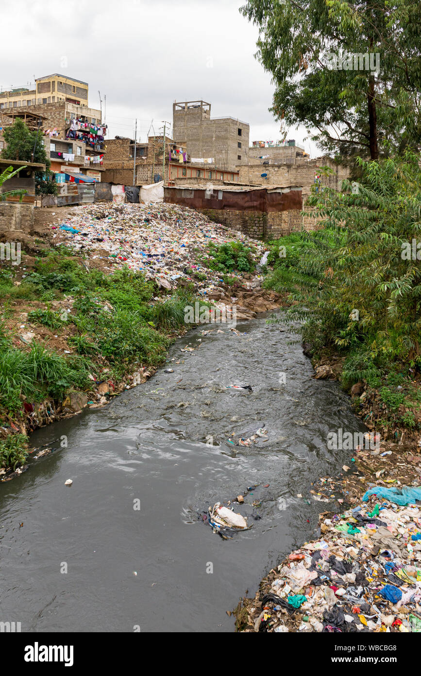 Mathare river with large pile of rubbish on the ground next to it ...