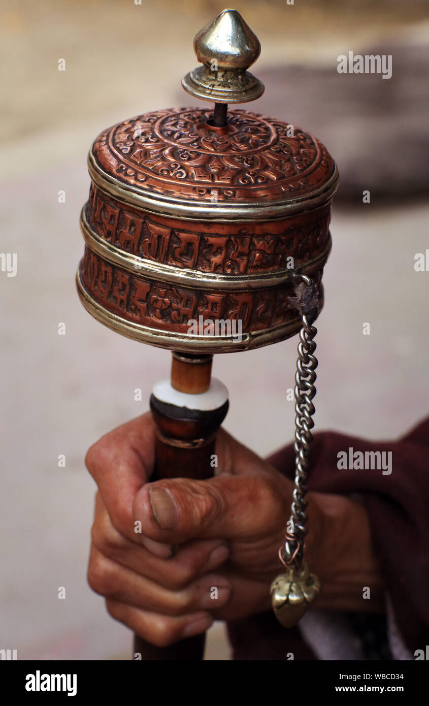 Buddhist monk with a prayer wheel in Thiksey monastery, close-up hand ...