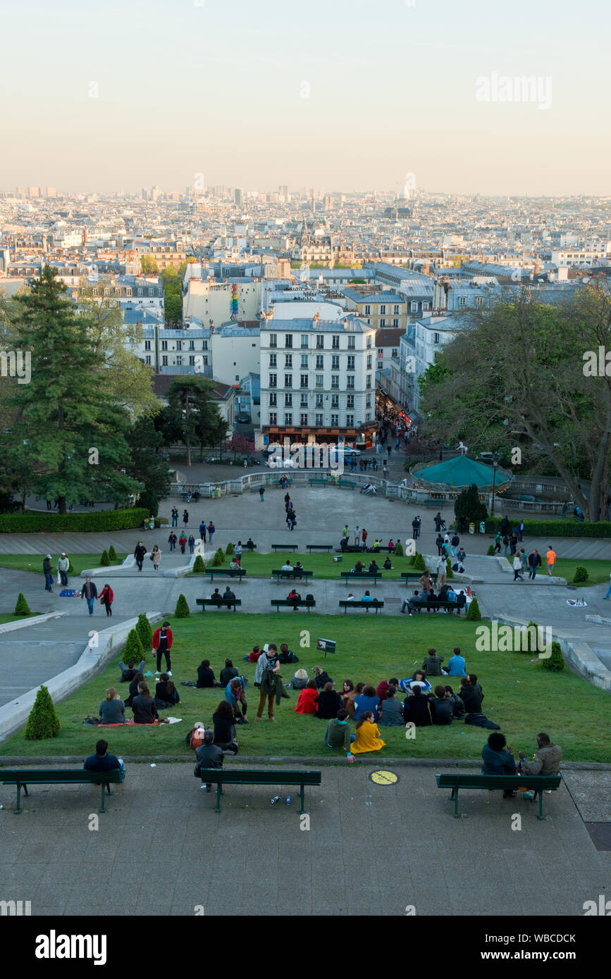 Tourist crowds enjoying evening sunset view over Paris from hill and ...