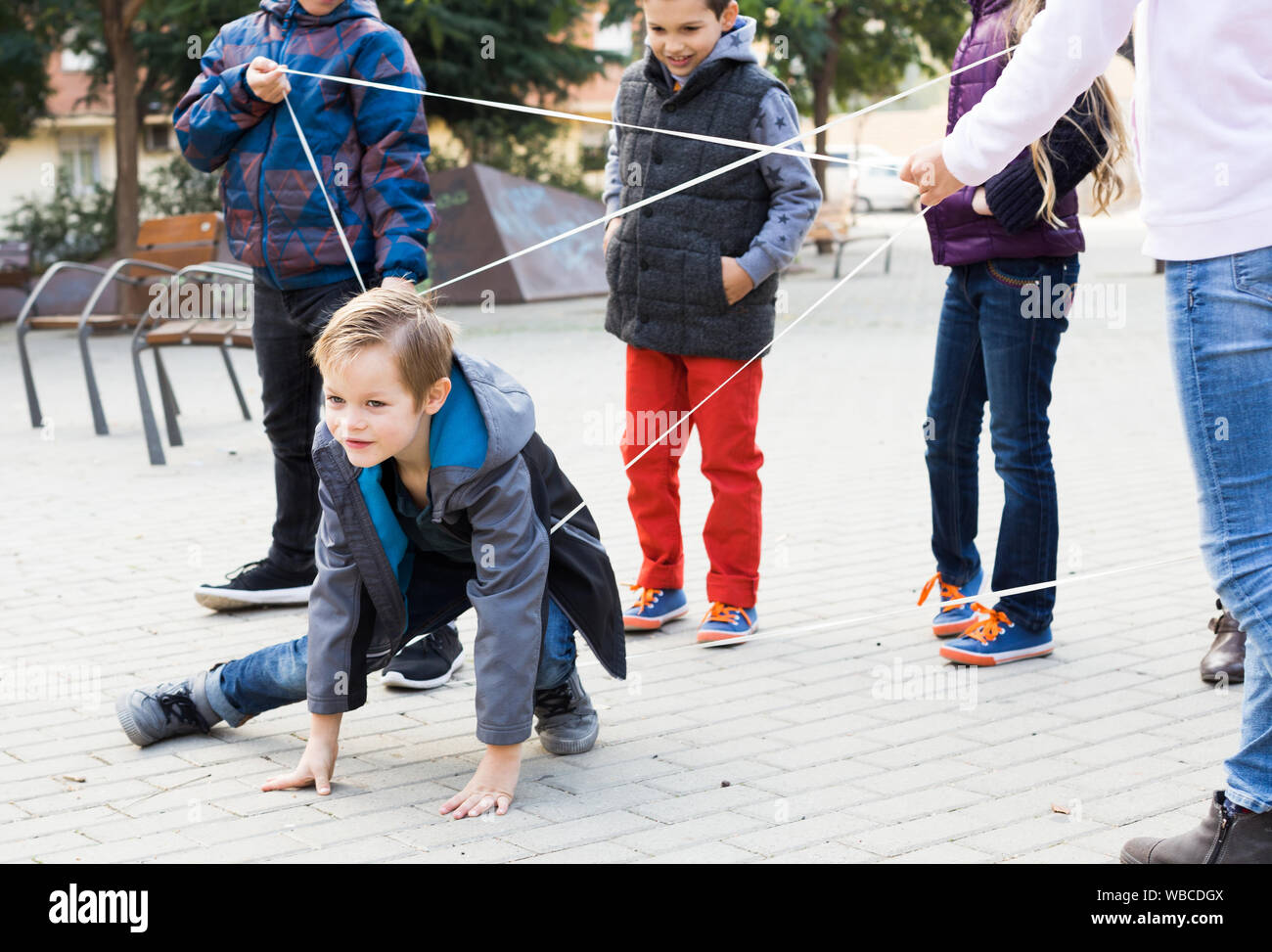 Boy smiling passes through the tangled rope Stock Photo - Alamy