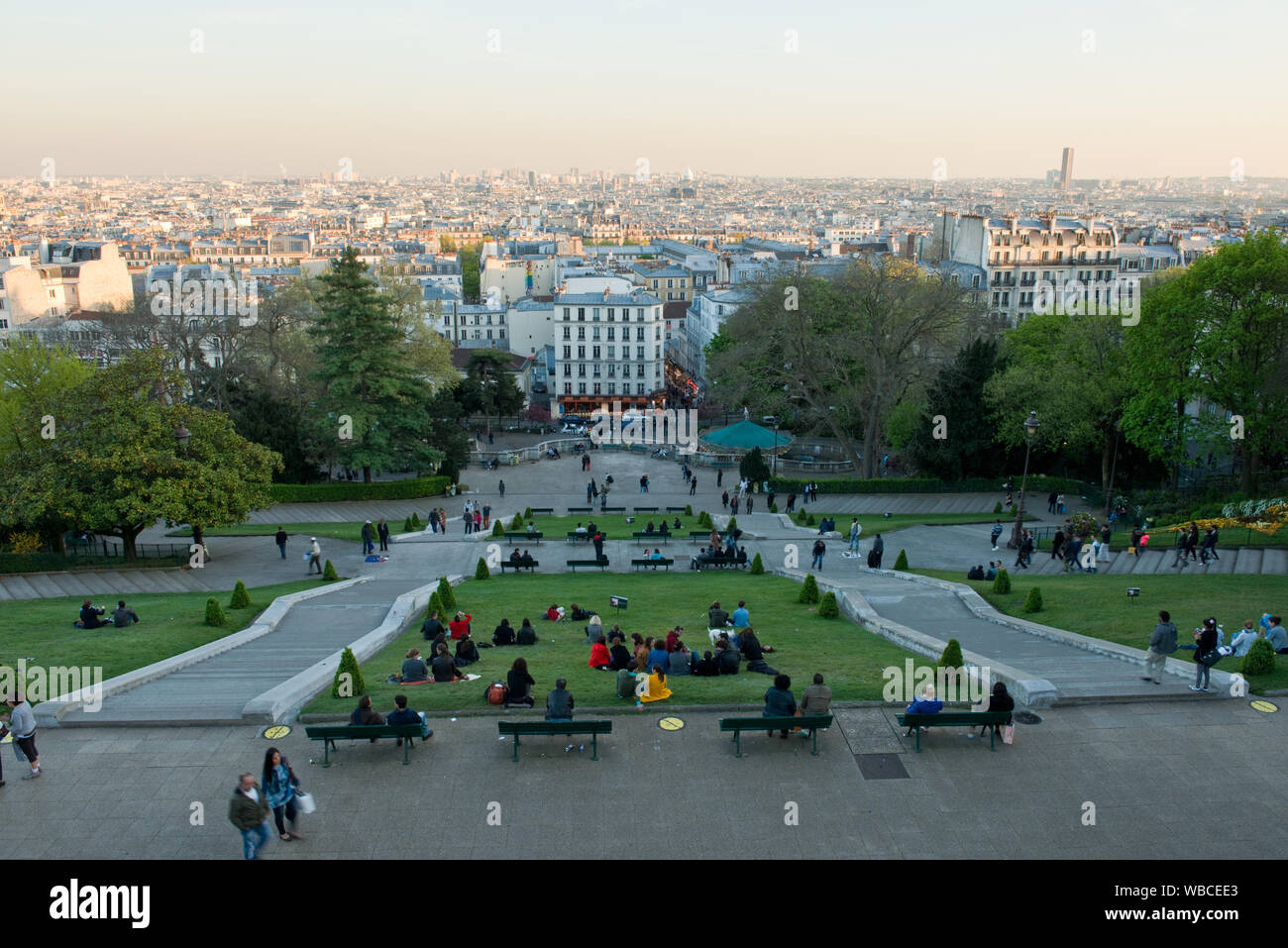Tourist crowds enjoying evening sunset view over Paris from hill and ...