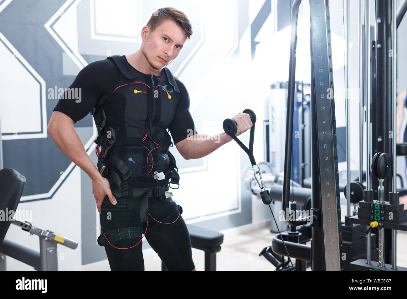 Sporty man performing full-body electric muscle stimulation training in ...