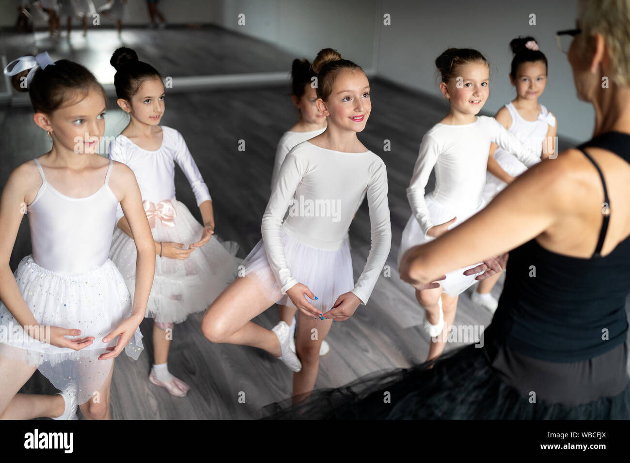 Little ballerinas in ballet studio. Group of happy girls exercising ...
