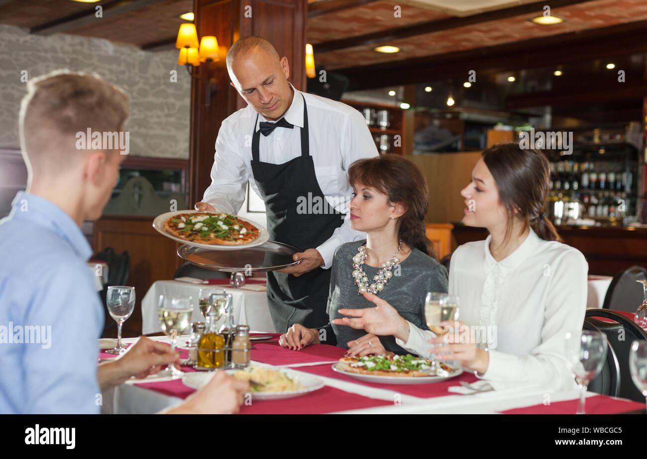 Waiter serving pizza hi-res stock photography and images - Alamy