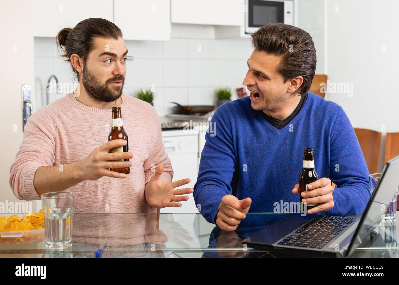 Two men friends are talking and drinking beer Stock Photo - Alamy