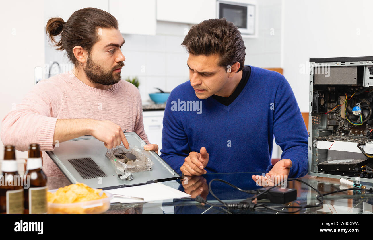 Two men repairing a desktop computer and drink beer Stock Photo - Alamy