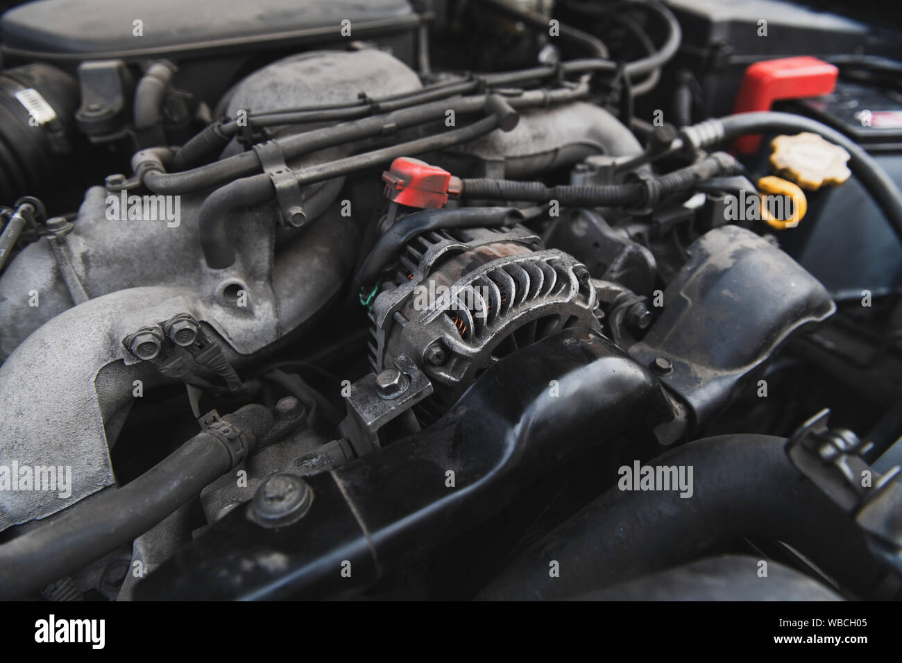 Dusty boxer engine under the hood. Generator and other parts of the ...