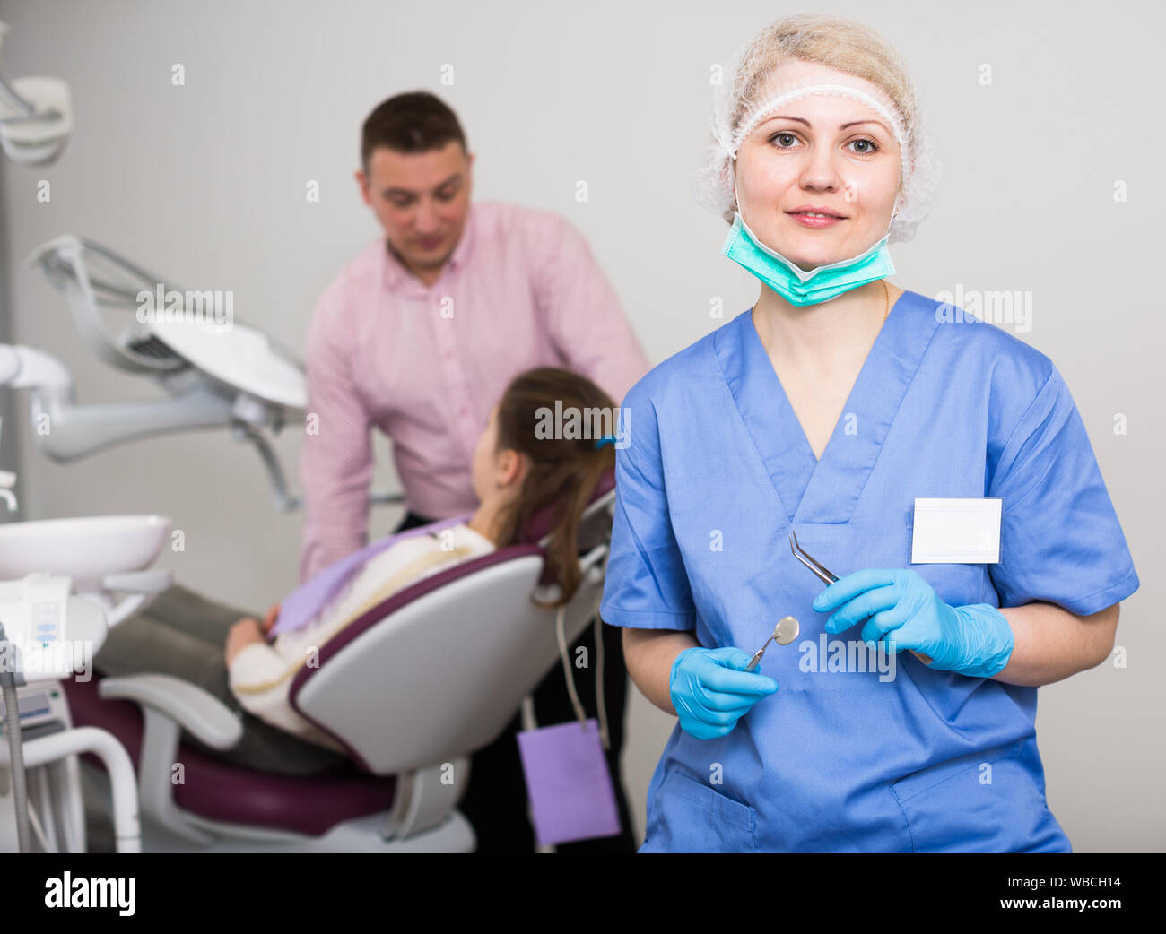 Portrait of female professional dentist in dental clinic with patients ...