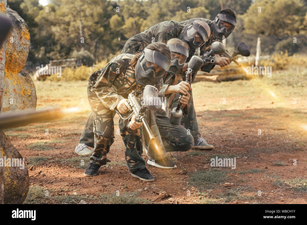 Expressive paintball team running with a marker guns on open playing ...