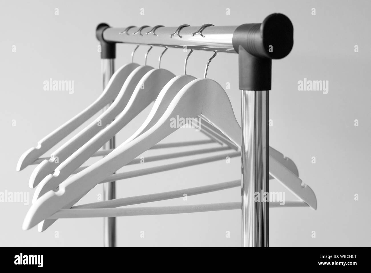 Empty clothes hangers on metal rail against grey background ...