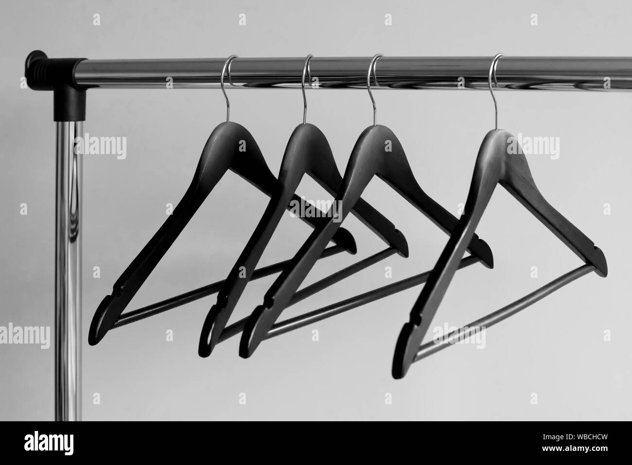 Empty clothes hangers on metal rail against grey background ...
